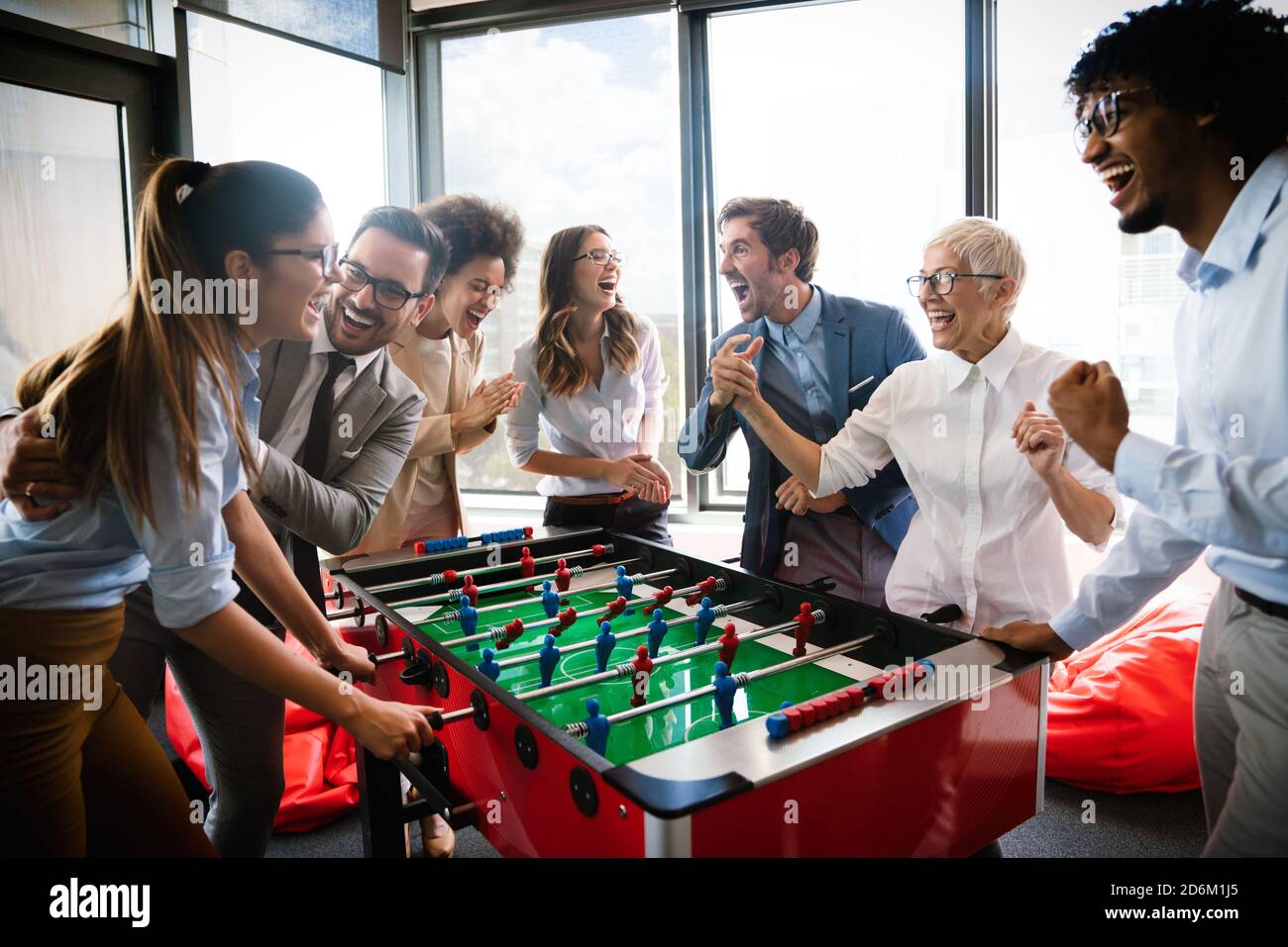 Excited diverse employees enjoying funny activity at work break ...