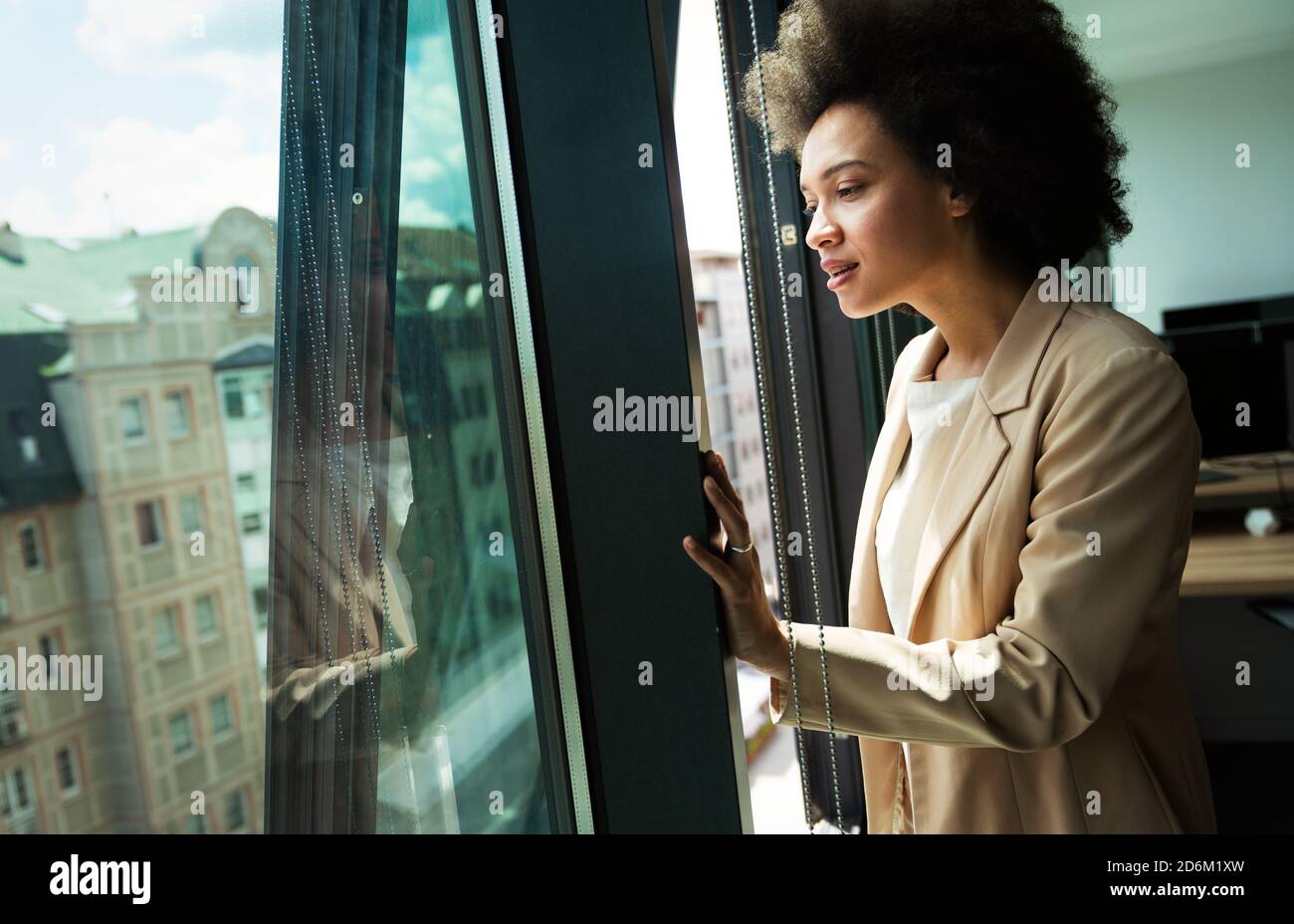 Beautiful african business woman looking outside window in office Stock ...