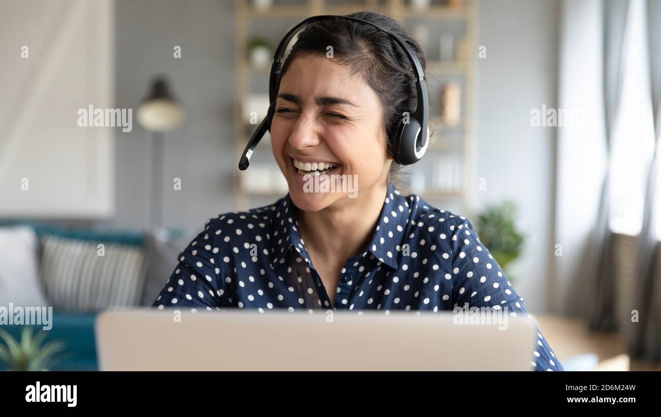 Indian female wear headset laughing during video call communication ...