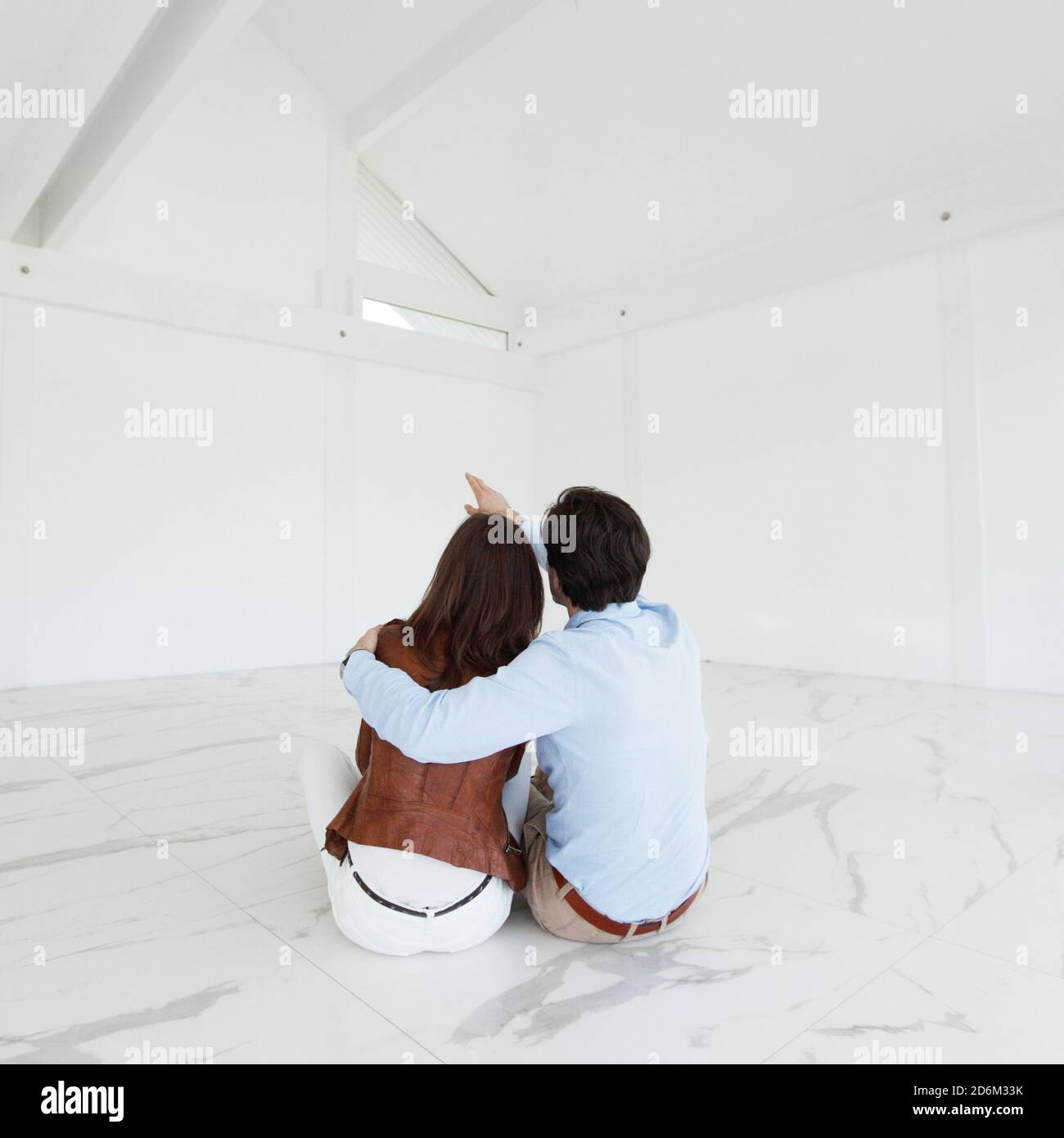 Happy couple at big bright comfort apartment planning their future ...