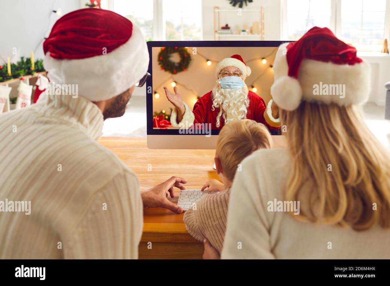 Parents and their little child having live video chat with Santa Claus ...