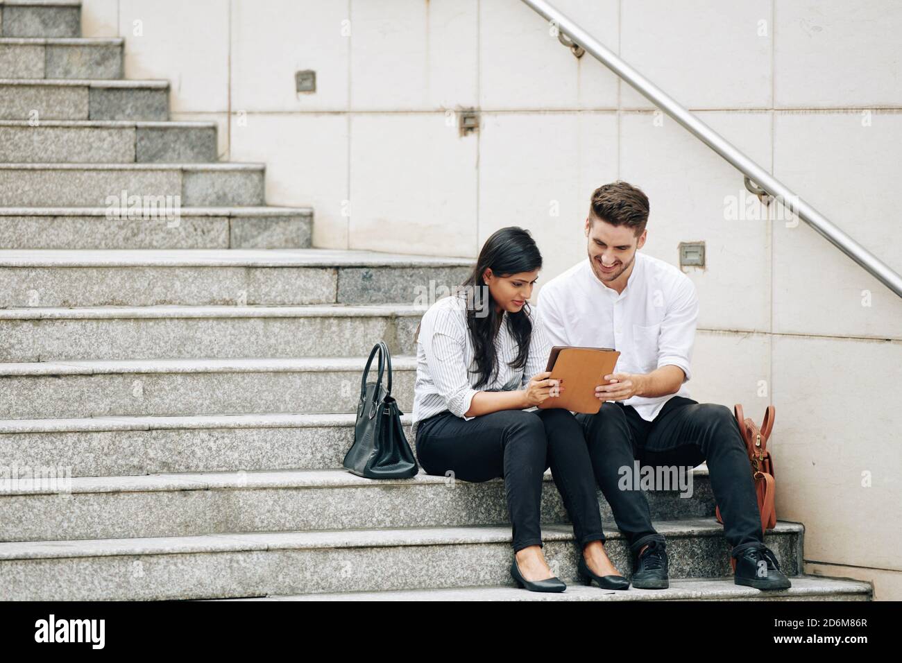 Business people sitting on steps Stock Photo - Alamy