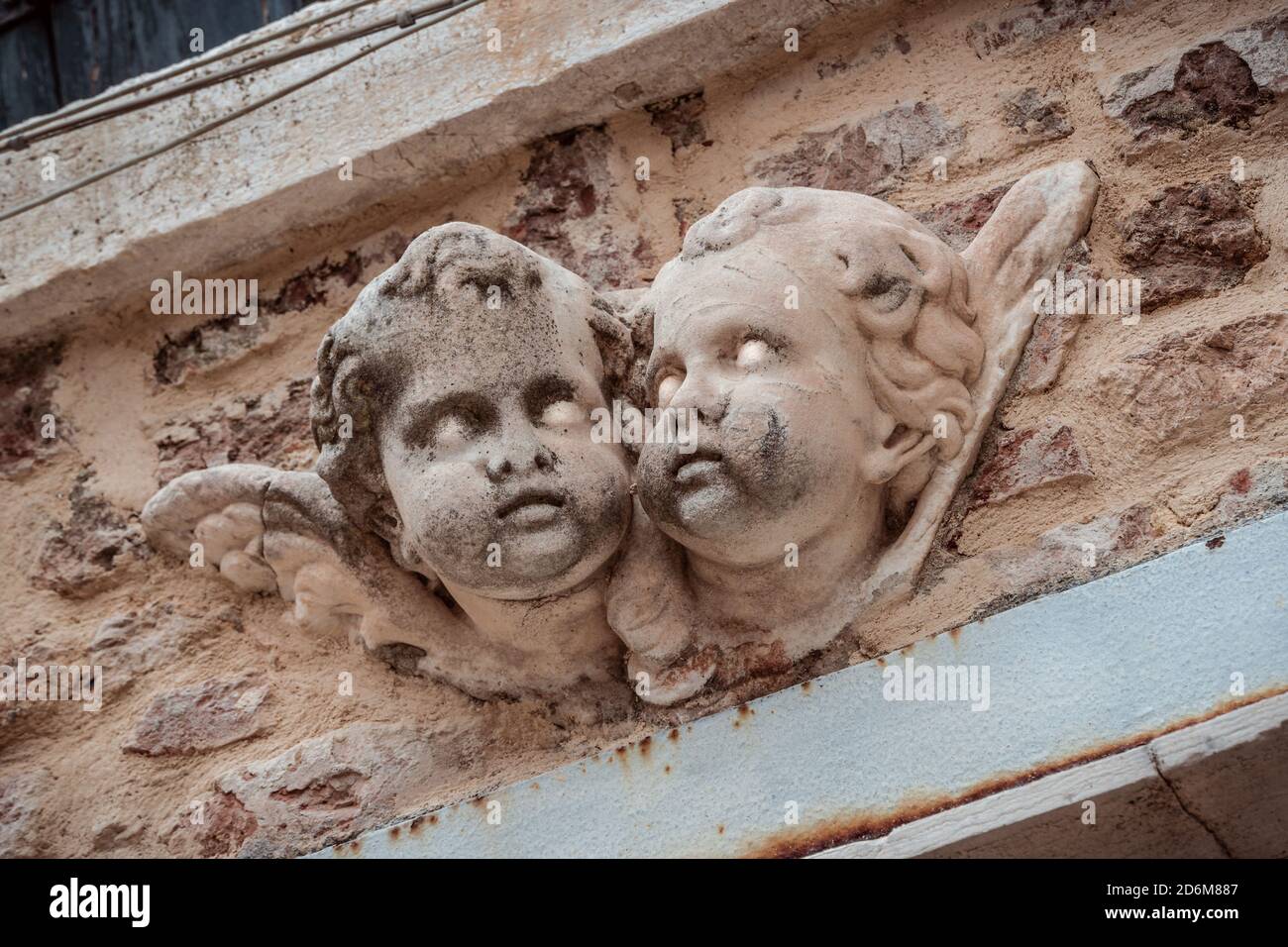 creepy childish angel faces with small wings on brick wall Stock Photo ...