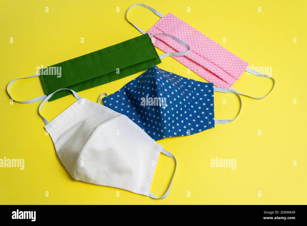 Four colored different reusable medical masks on yellow isolated ...