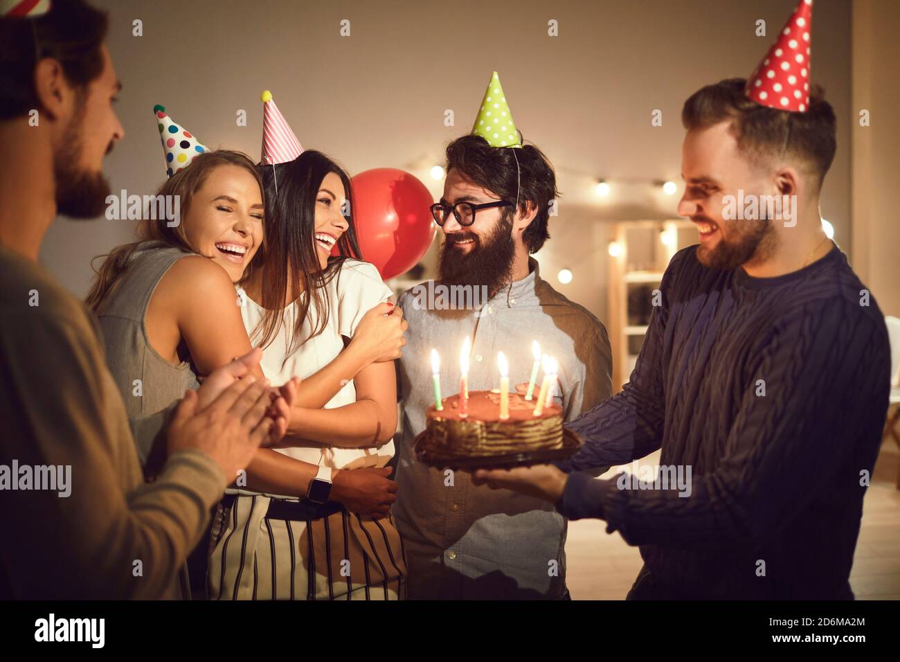 Group of happy young people giving delicious cake to their friend for ...