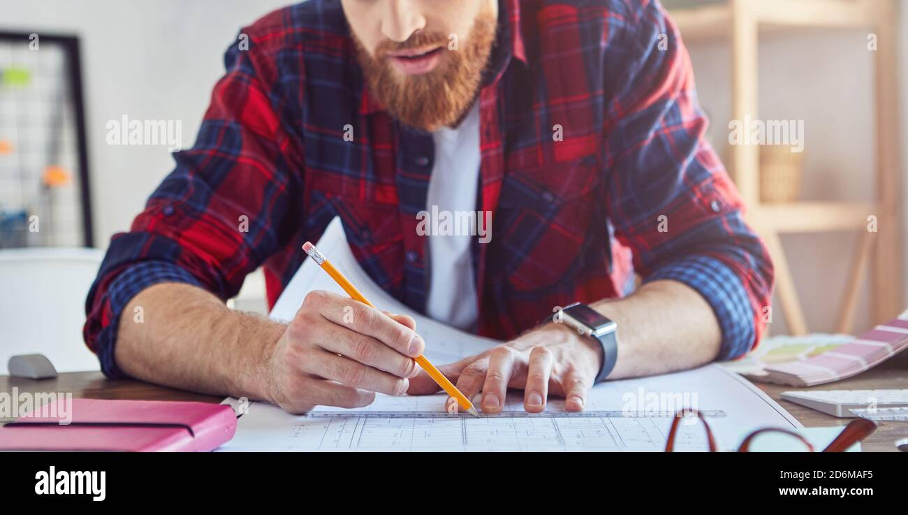 Creative engineer working on an architecture model with pencil at his ...