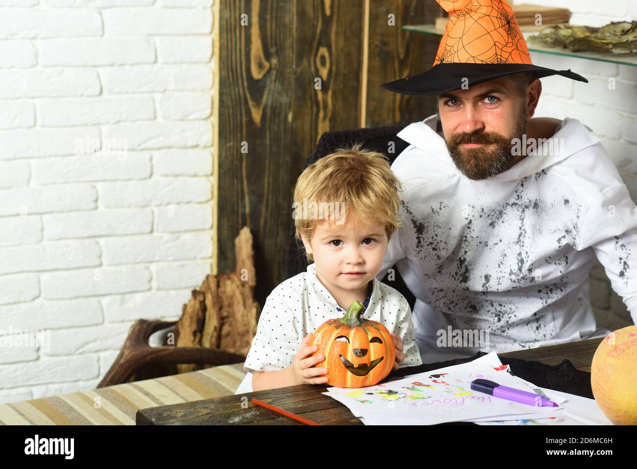 Guy and boy on wooden and white brick wall background. Witcher and ...