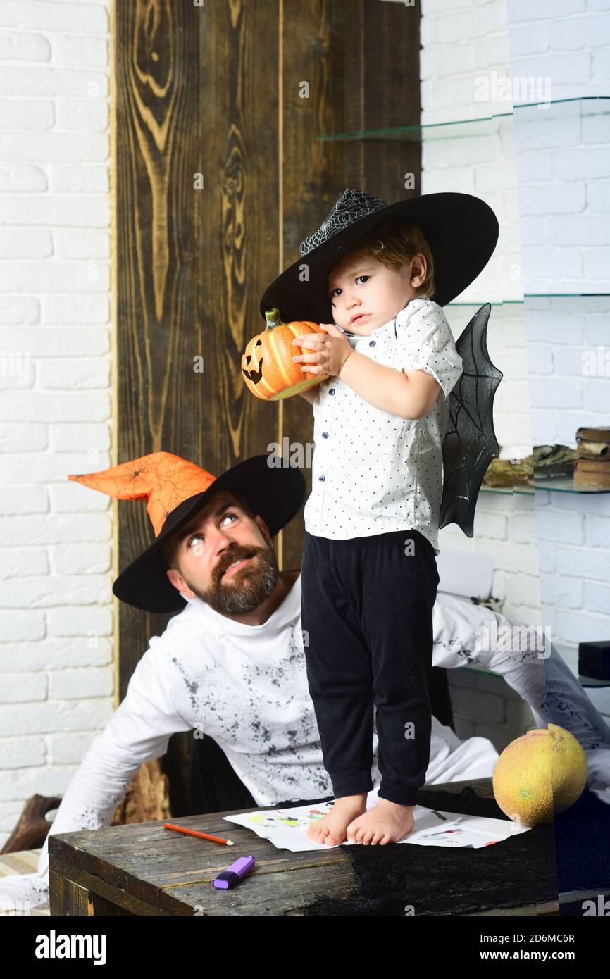 Witcher and little magician make Halloween decor. Guy and boy on wooden ...