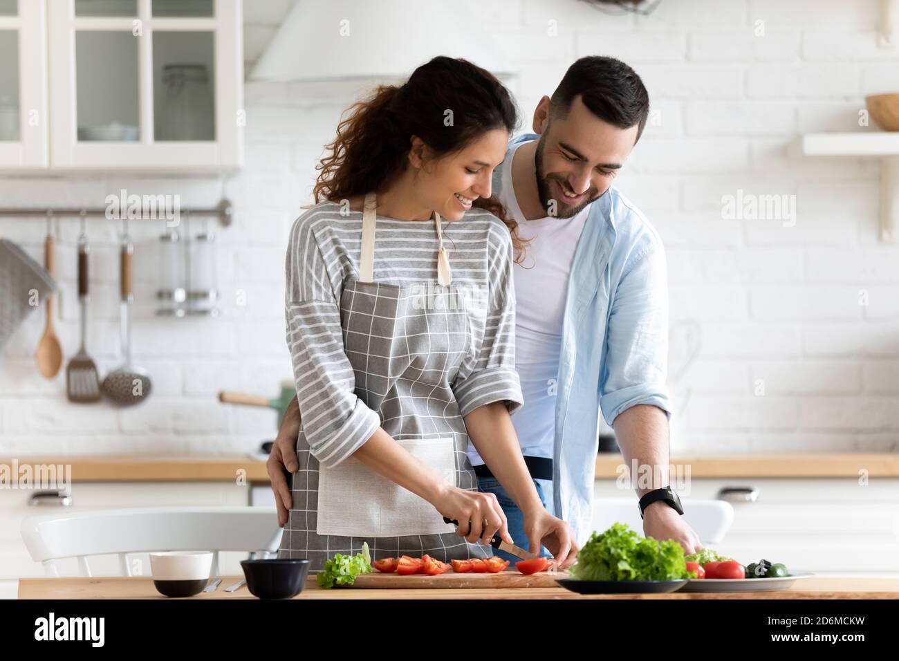 Happy loving couple preparing dinner in kitchen together, hugging Stock ...