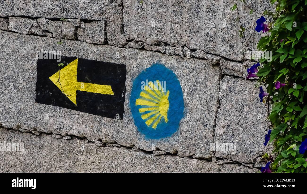 Arrow and shell sign on a wall indicating to pilgrims the direction to ...