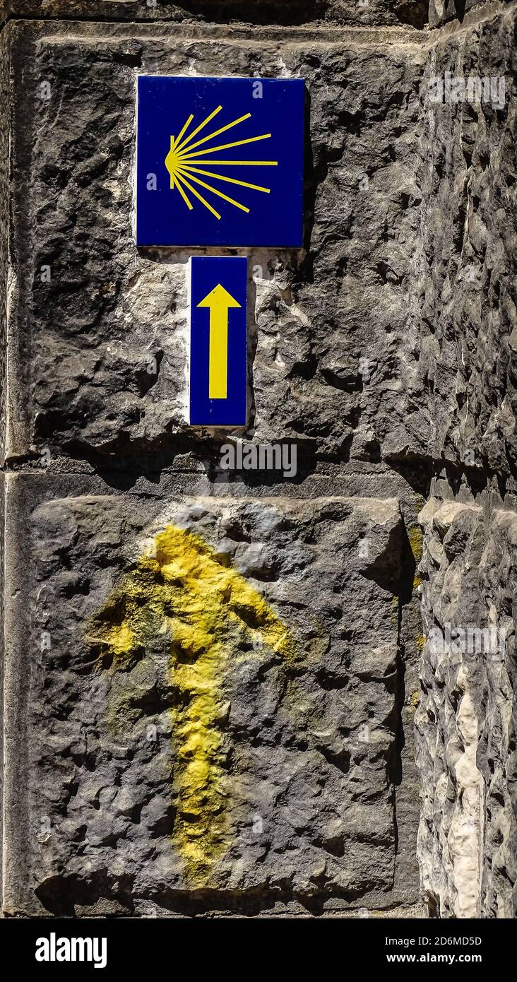 Arrow and shell sign on a wall indicating to pilgrims the direction to ...