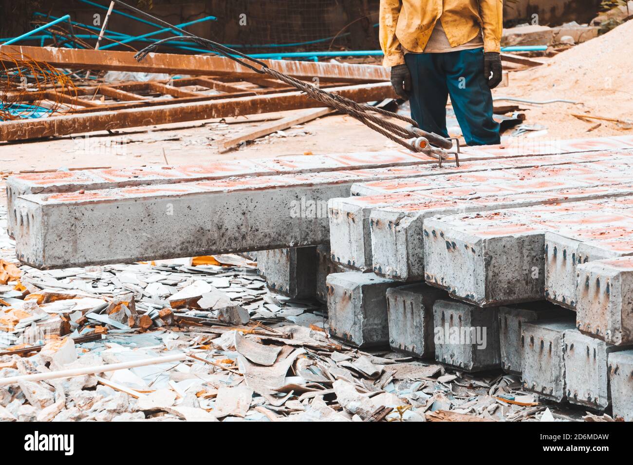 pile concrete pillars on the ground worker move by sling in ...