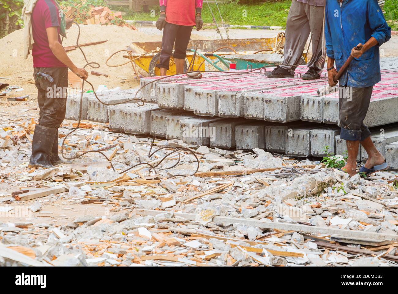 worker move pile concrete pillars on ground by sling in construction ...
