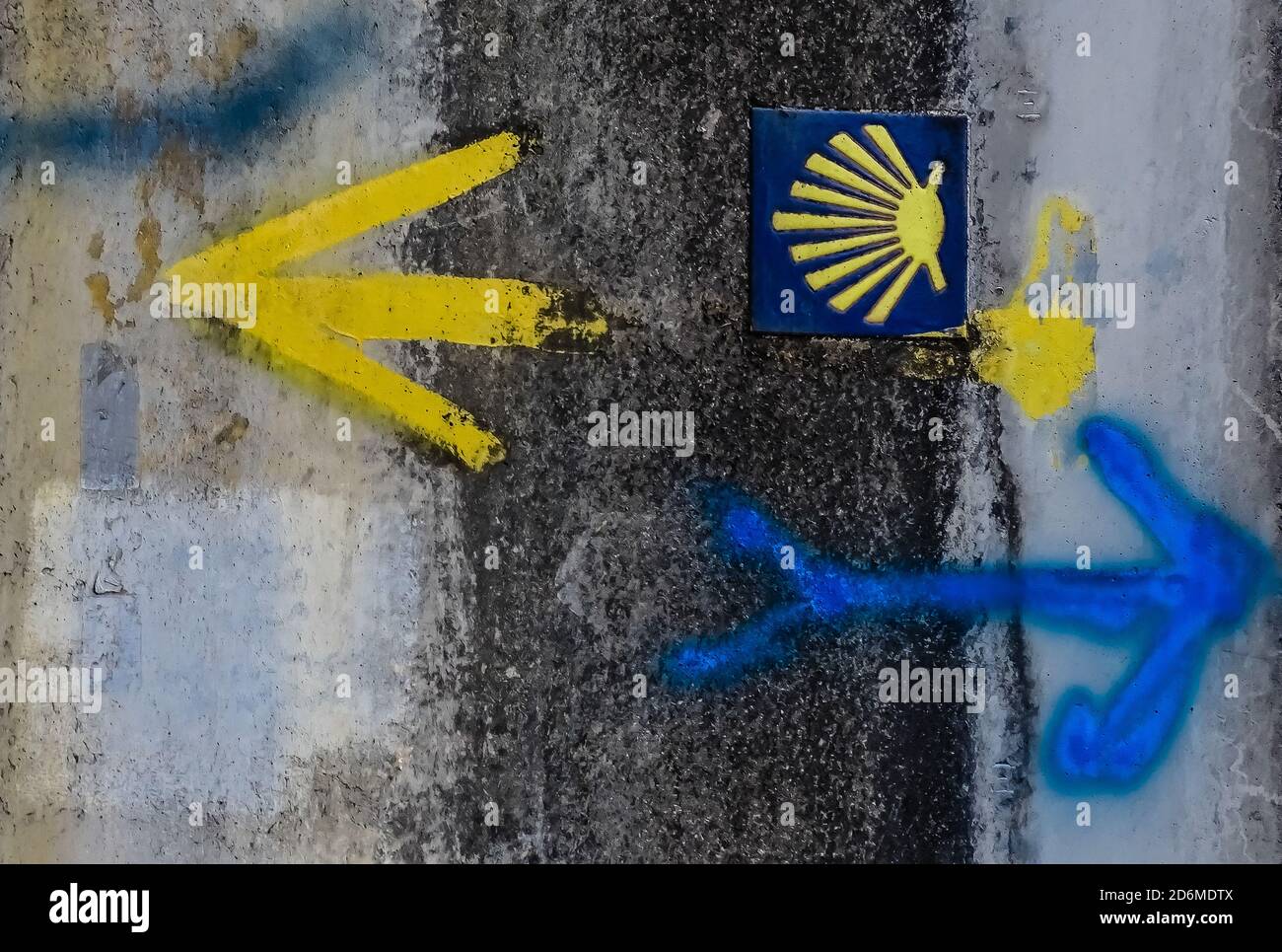 Arrow and shell sign on a wall indicating to pilgrims the direction to ...