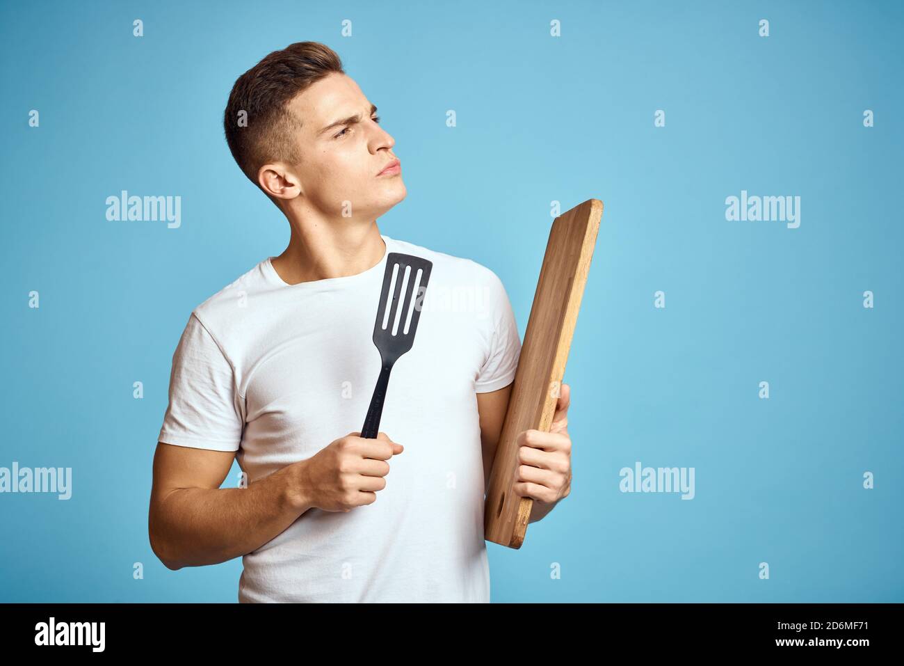 energetic guy with wooden kitchen board and spatula fun emotions Stock ...