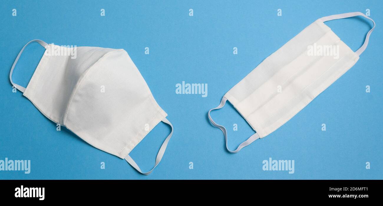 Two white reusable medical masks on dark blue background isolated ...