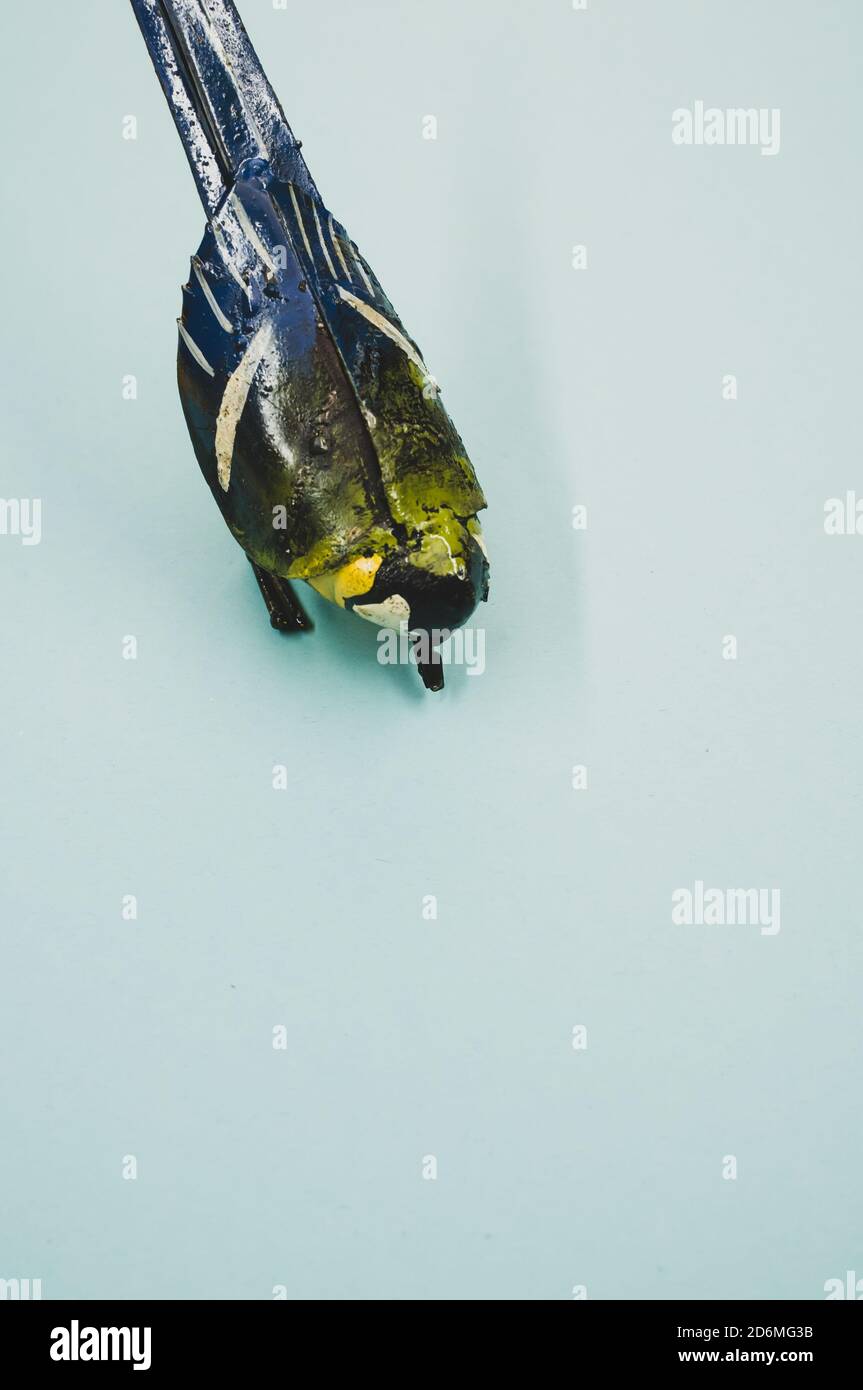 Vertical shot of a small handmade painted bird figure isolated on a ...