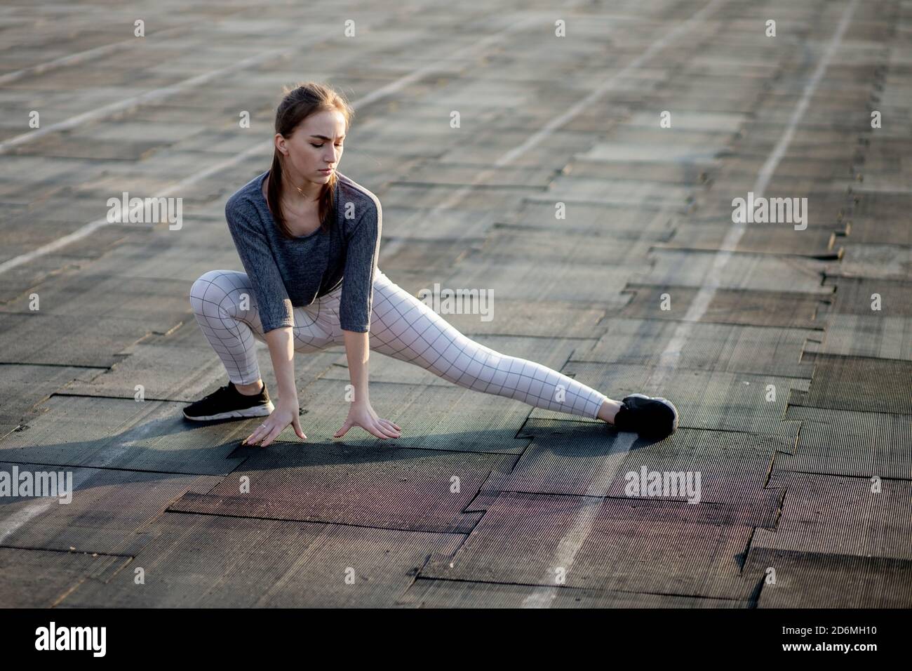 Female runner stretching legs on running track Stock Photo - Alamy