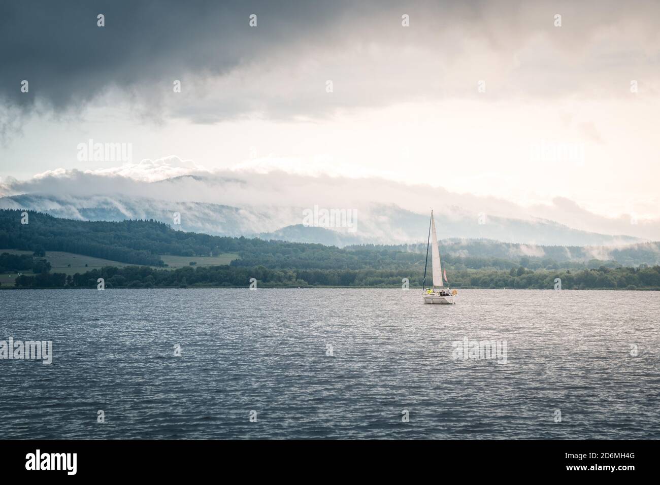 Sailing boat floats on the lake with stormy clouds sky. Autumn sailboat ...