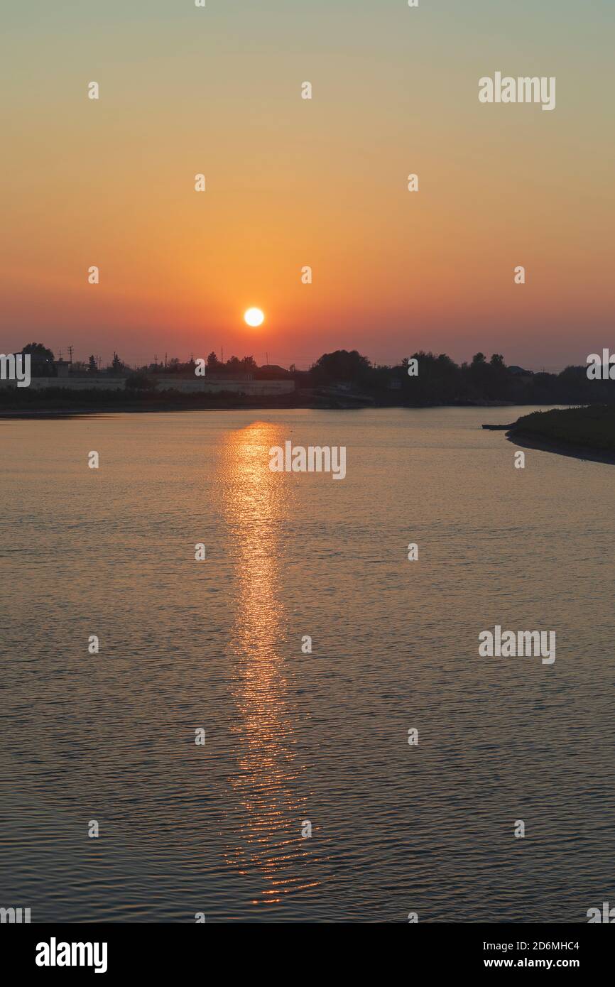 The Kura river flowing through the city of Neftechala at sunset Stock ...