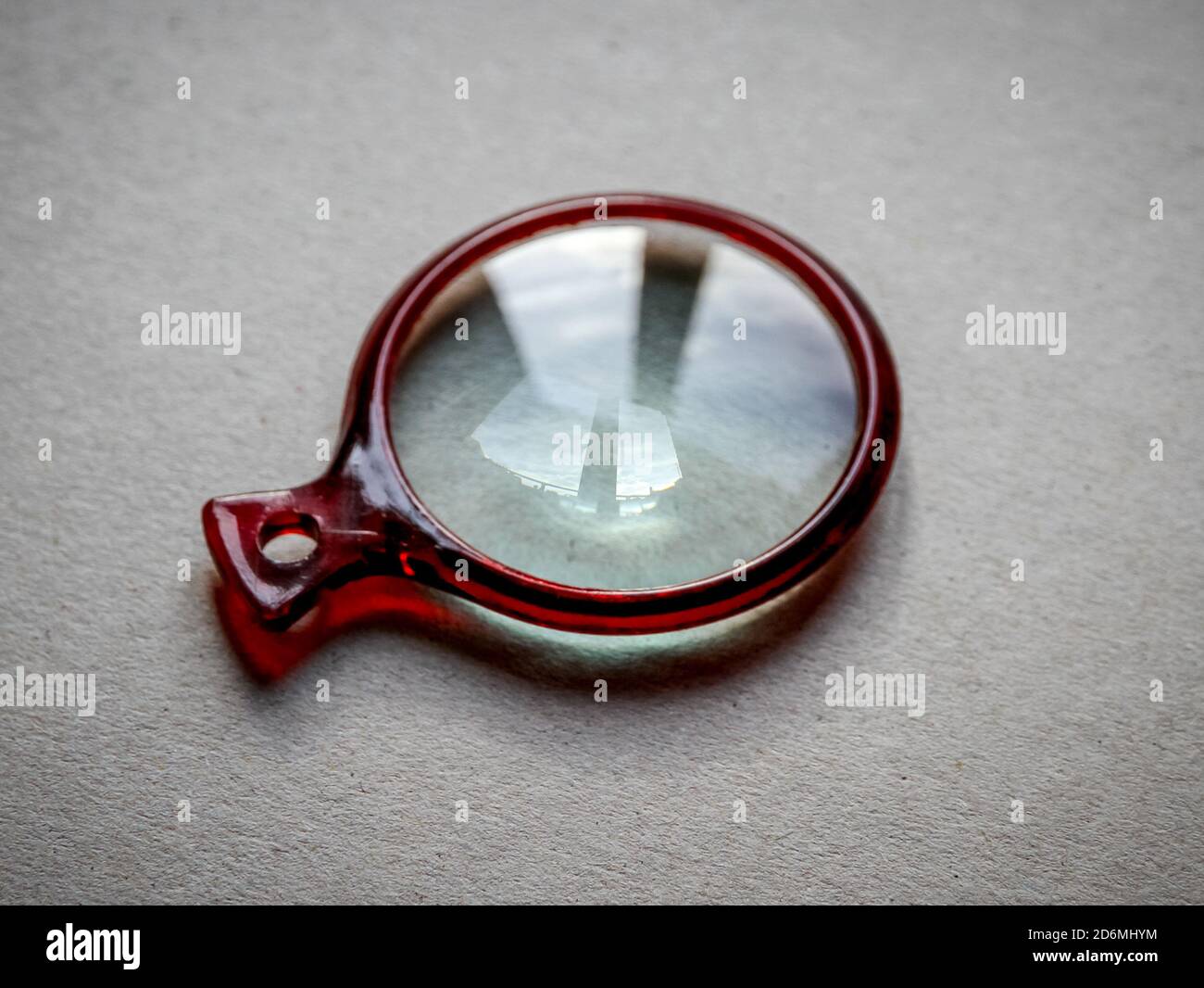 Magnifying glass closeup view on a paper background Stock Photo - Alamy