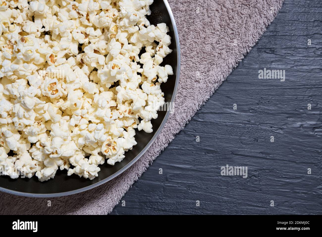 Tasty salted popcorn in pan on dark background Stock Photo - Alamy