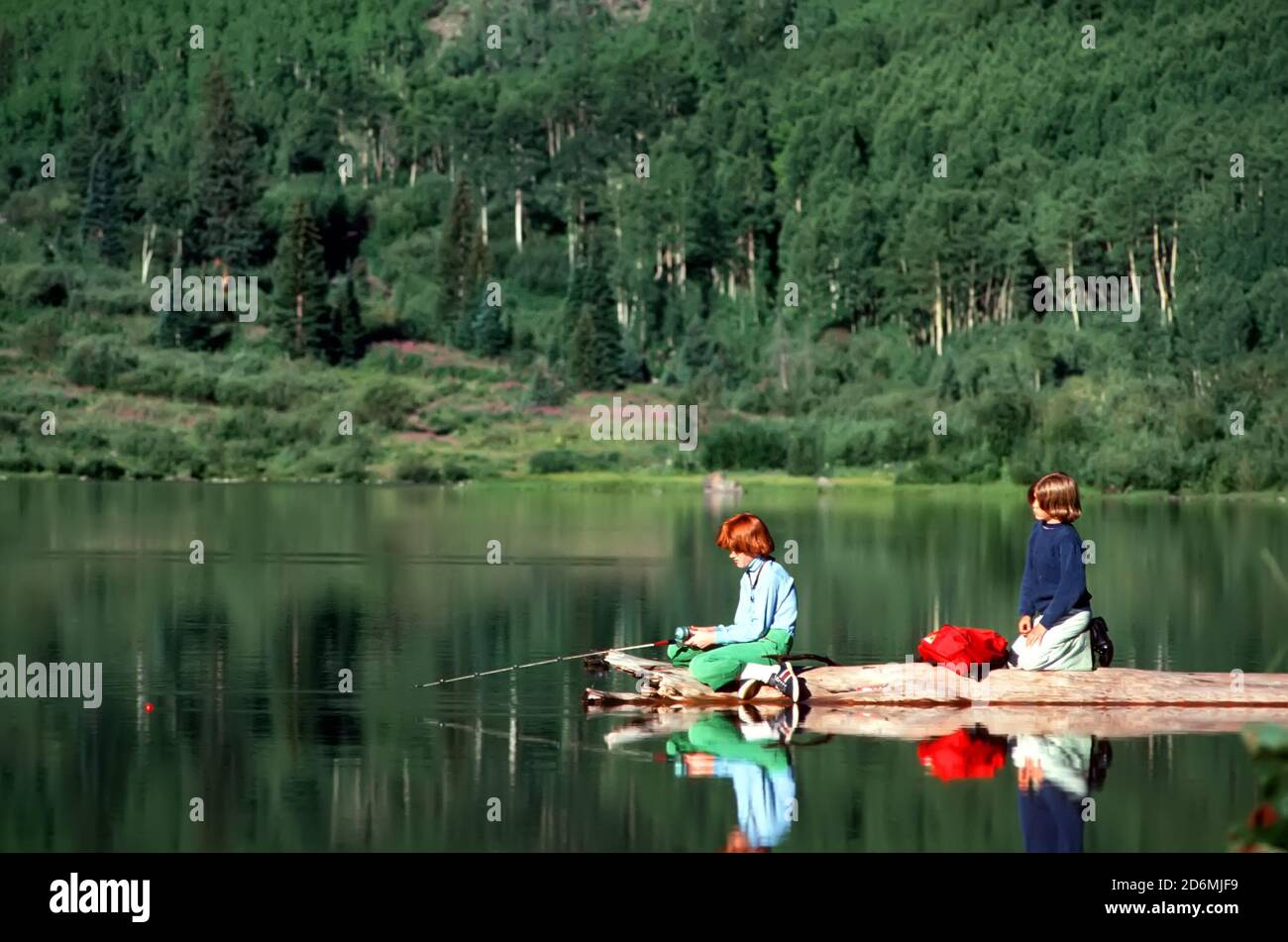 Two girls fish at the base of Maroon Bells Mountain, Colorado Stock ...