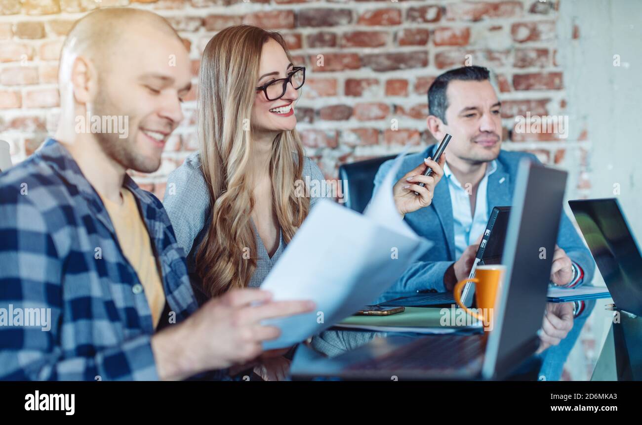 Businesspeople in startup company looking at graphs and figures Stock ...