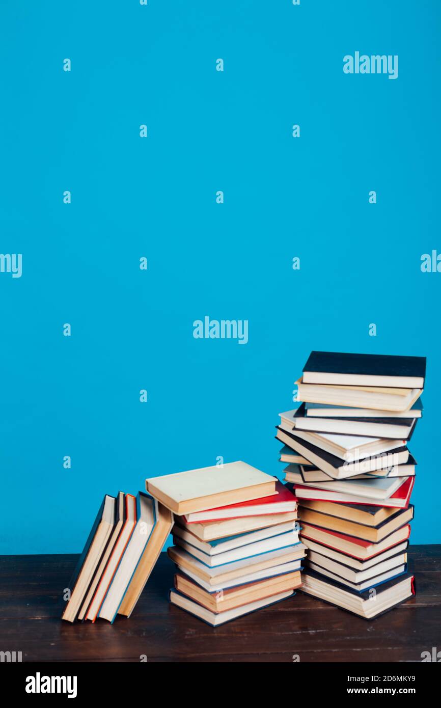 stacks of books for education in the college library on a blue ...