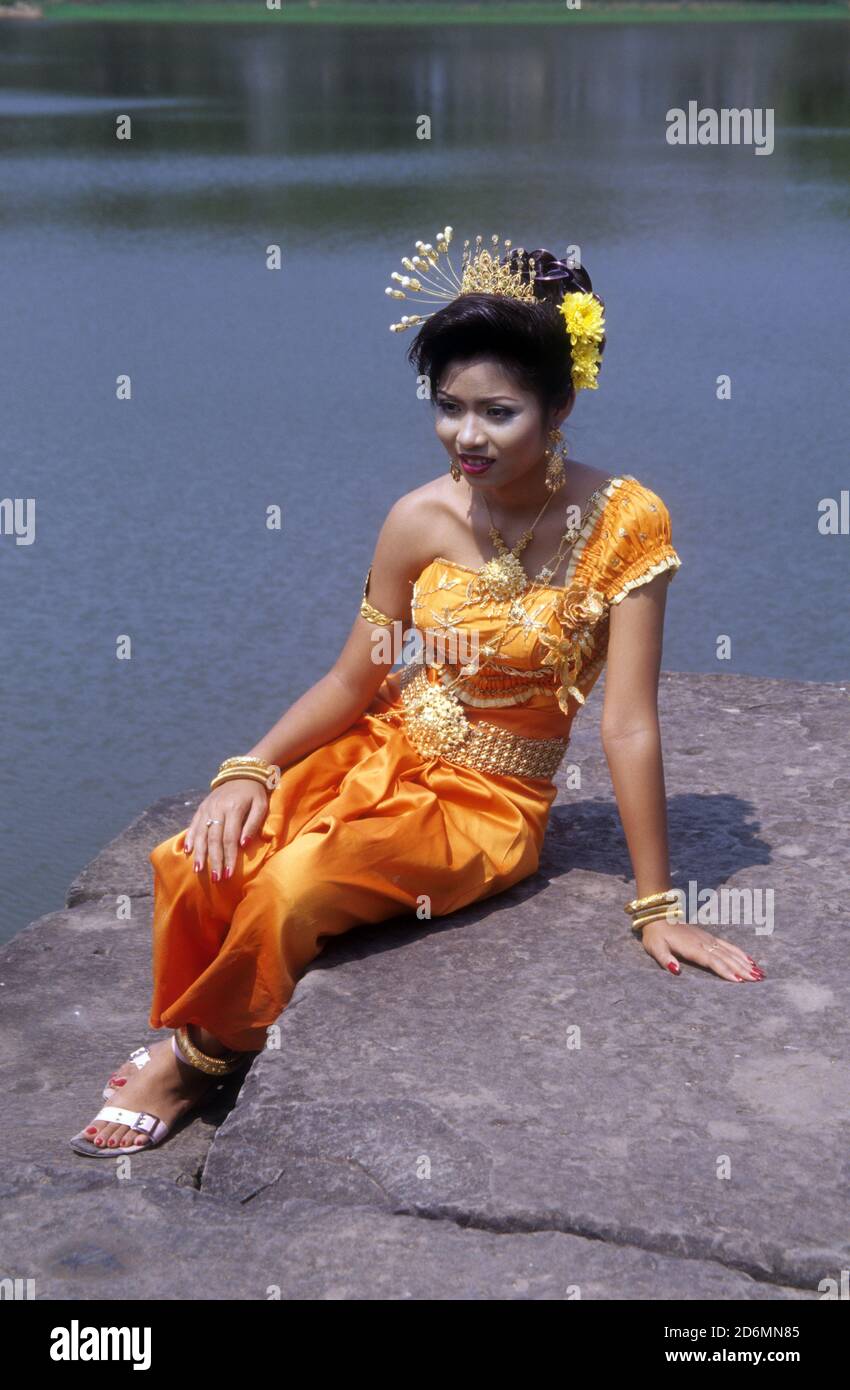 A Cambodian bride in traditional dress poses for a pre-wedding photo at ...