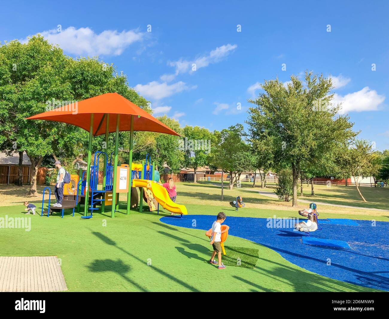 Modern playground with sun shade sails, artificial grass and kids ...