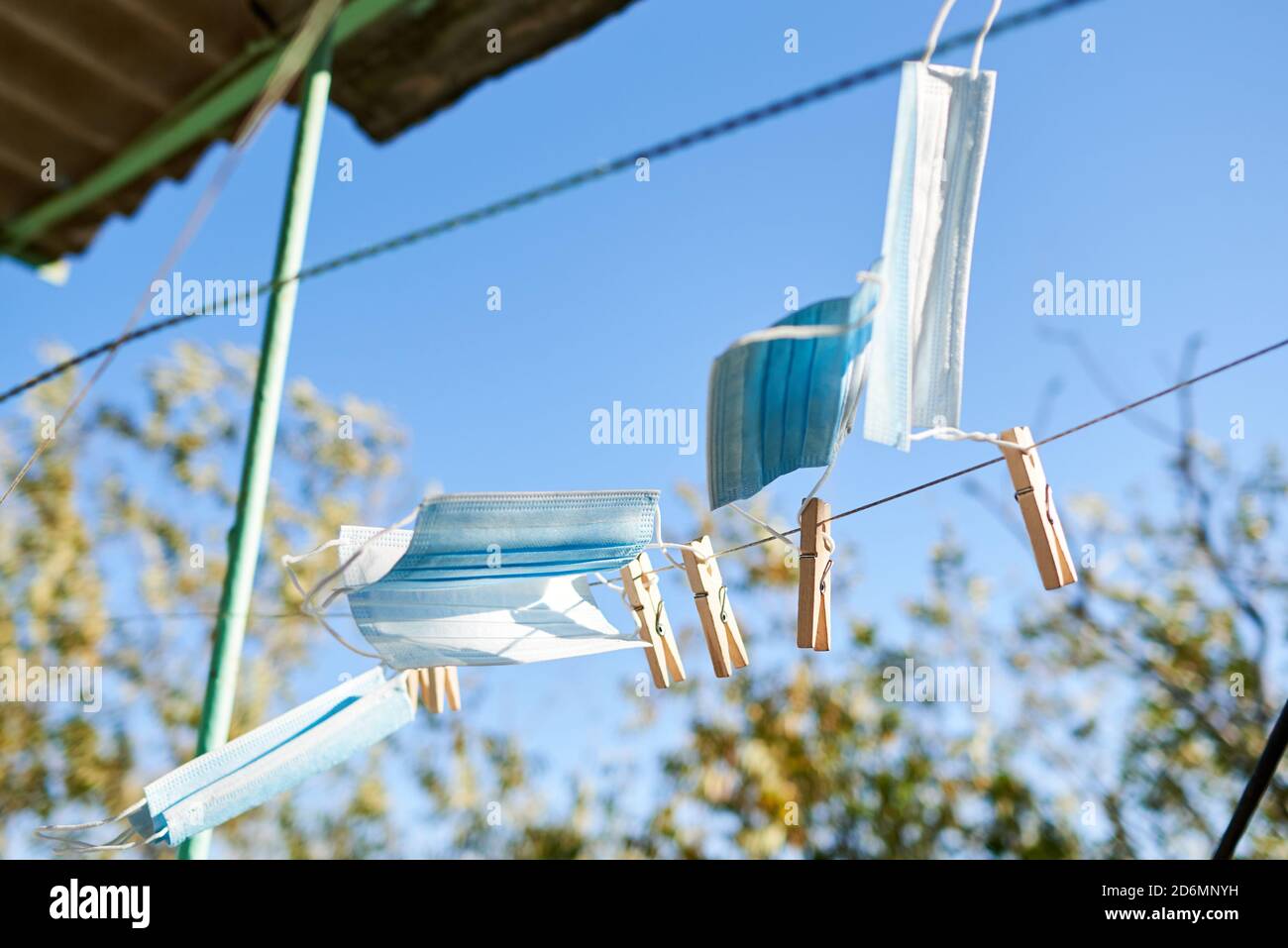 Sunlit face masks are hung to dry for disinfection fastened by wooden ...