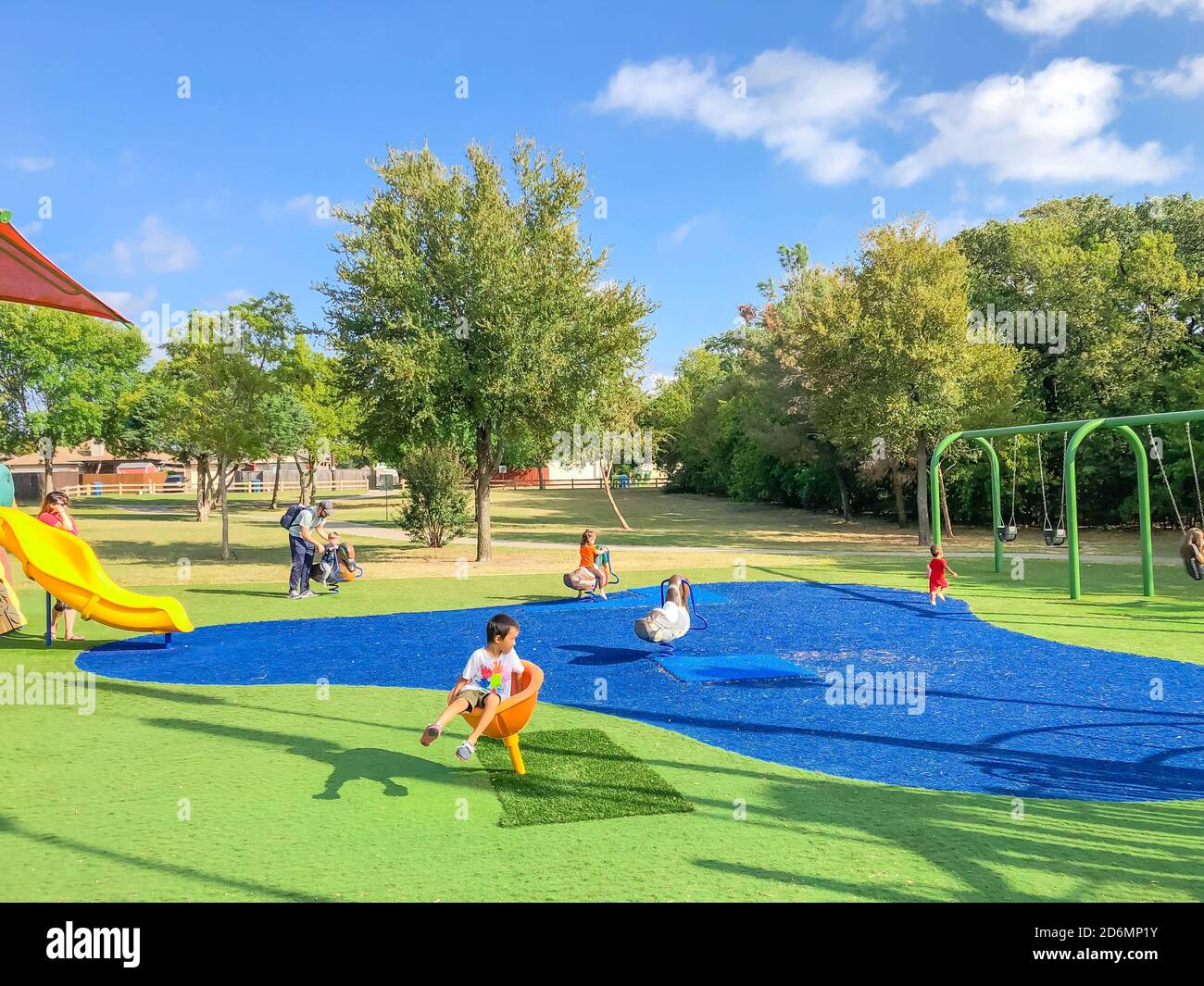 Modern playground with sun shade sails, artificial grass and kids ...