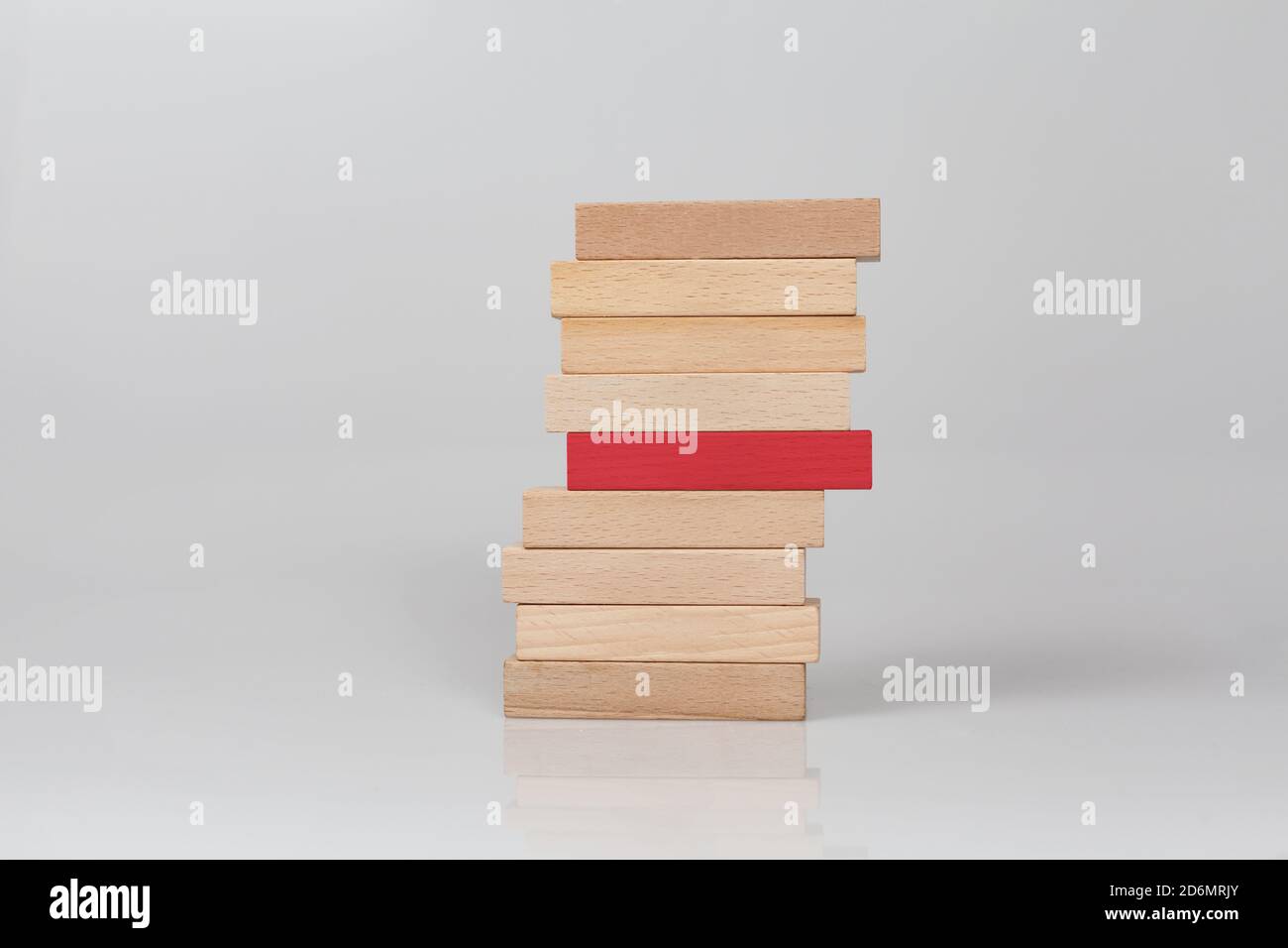 Red block under of wooden tower on white background Stock Photo - Alamy
