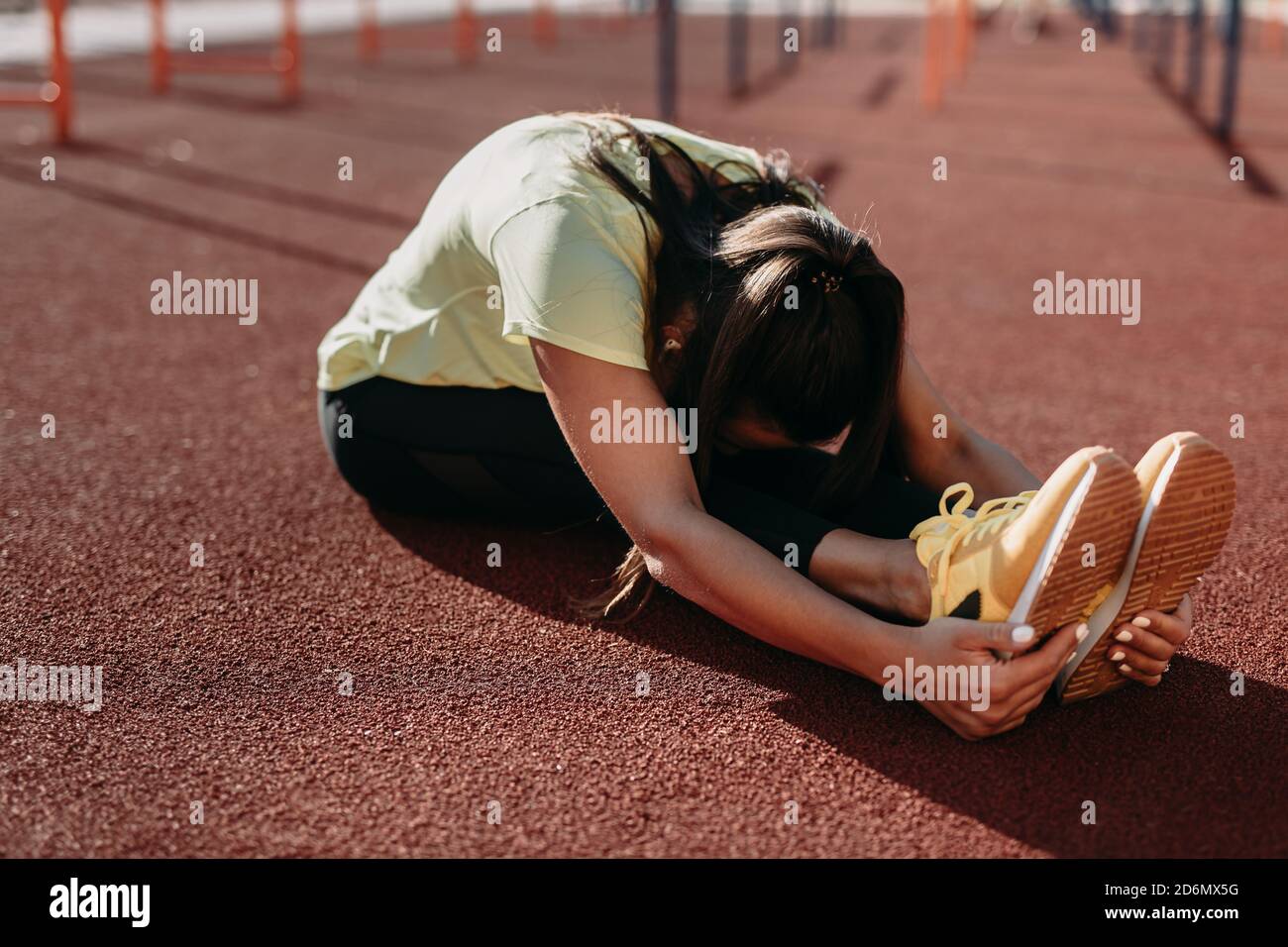 Flexible young brunette in sport clothing stretching body Stock Photo ...