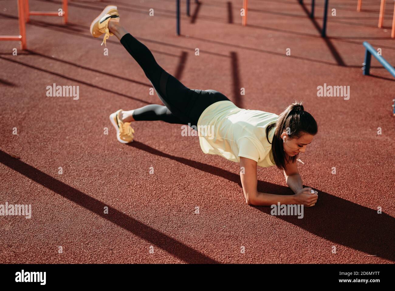 Athletic woman standing in plank position on fresh air Stock Photo - Alamy