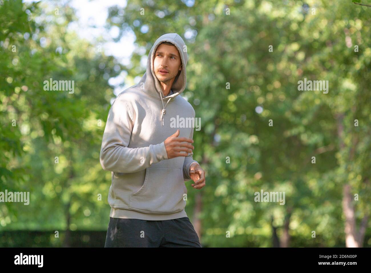 Sportsman runs along the road in the forest. The concept of sport and a ...
