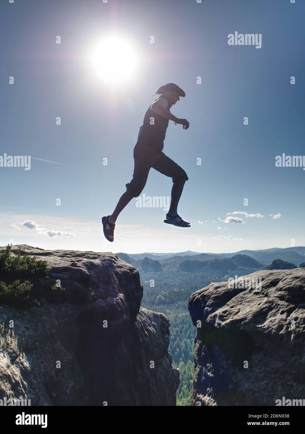 Man jump. Silhouette of hiking man jumping over the mountains at sunset ...
