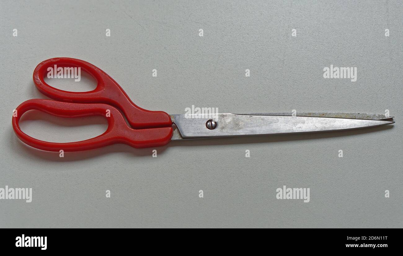 Long scissors with sharp edge and red handles Stock Photo - Alamy