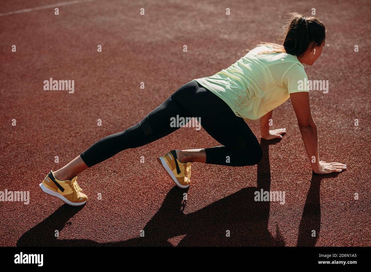 Back view of strong lady doing abs exercises at red court Stock Photo ...