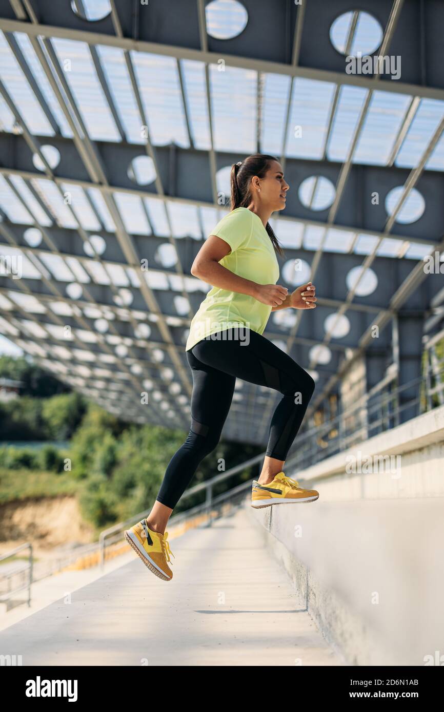 Young sportswoman jogging on steps on fresh air Stock Photo - Alamy