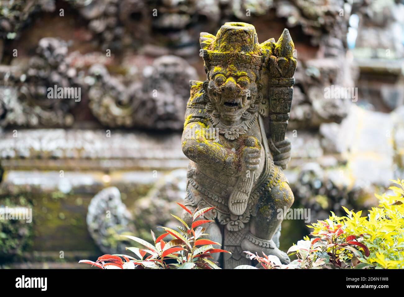 Stone statue of deity surrounded by vegetation, Bali island, Indonesia ...