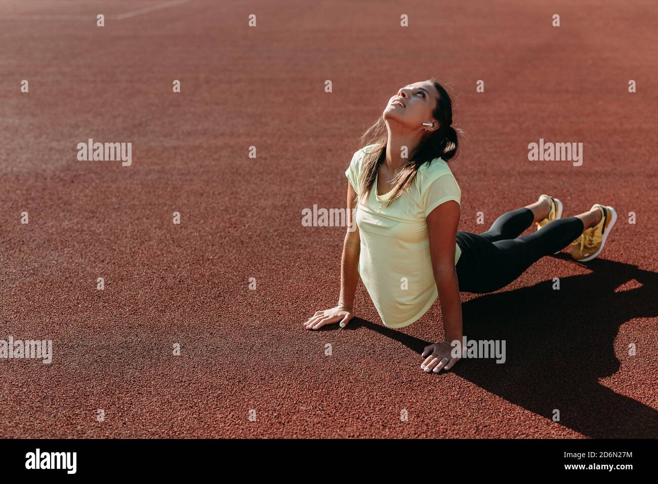 Flexible young woman stretching body outdoors Stock Photo - Alamy
