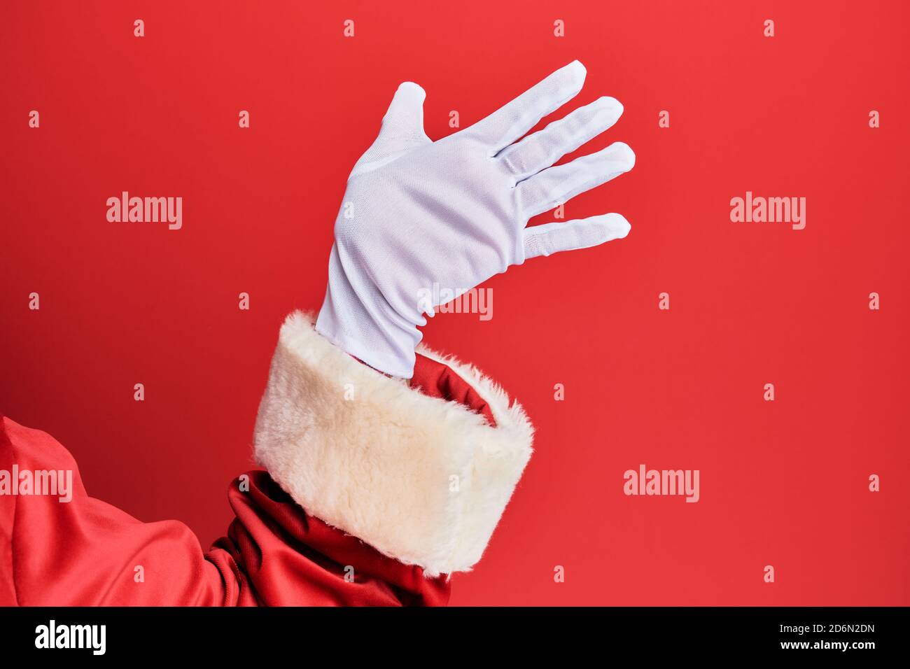 Hand of a man wearing santa claus costume and gloves over red ...