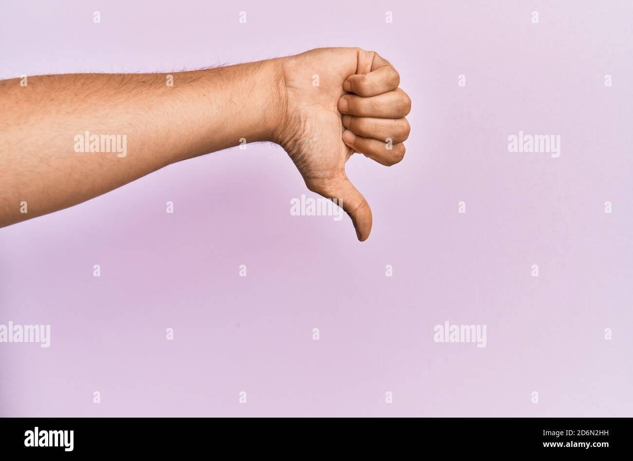 Arm and hand of caucasian young man over pink isolated background doing ...