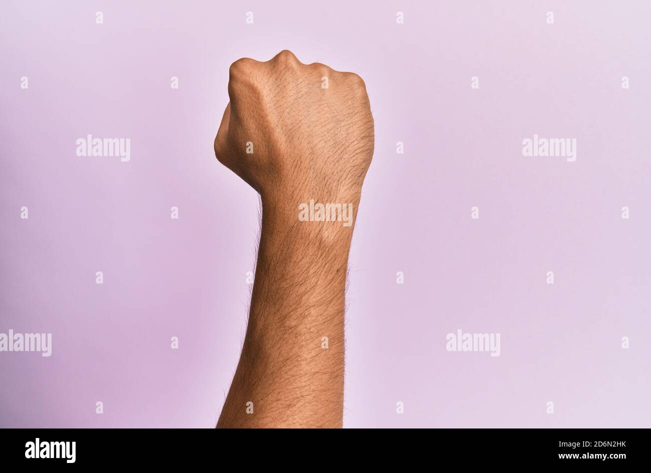 Arm and hand of caucasian young man over pink isolated background doing ...
