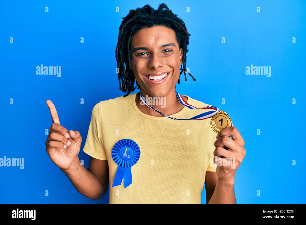 Young african american man wearing first place badge holding medal ...