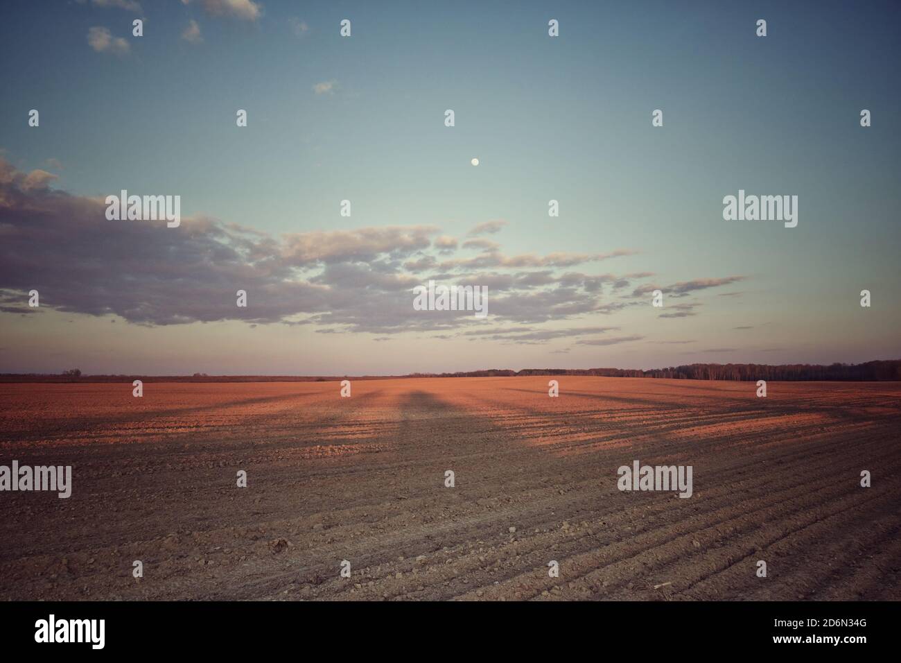 Cloudy evening sky over an empty agricultural field. Bright sunset ...