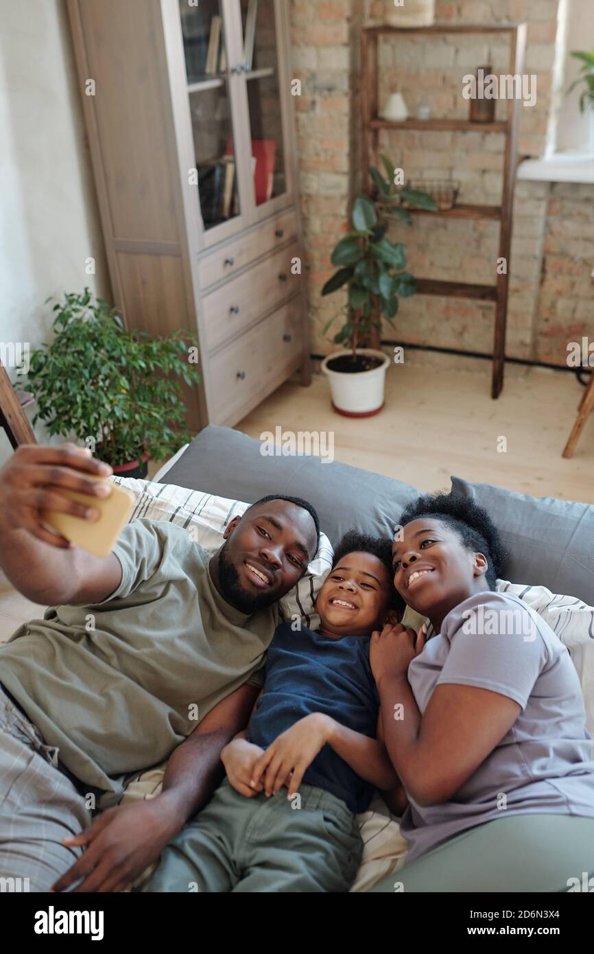 Joyful young family of affectionate parents and their little son making ...