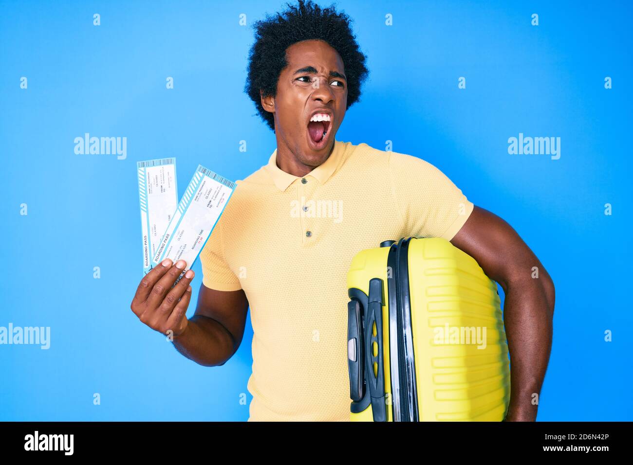 Handsome african american man with afro hair holding cabin suitcase and ...